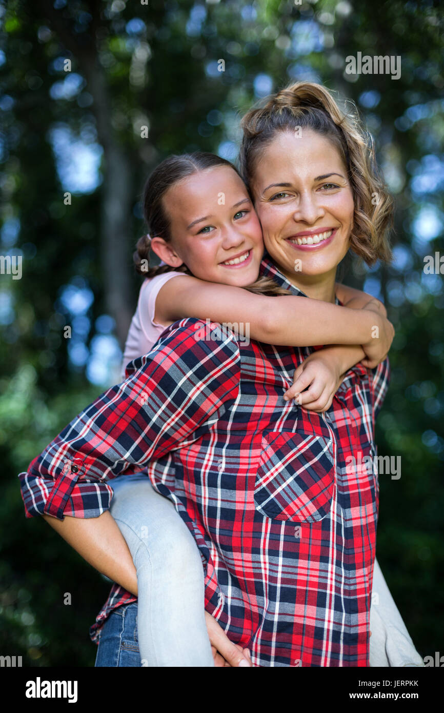 Mother carrying daughter on back Stock Photo - Alamy