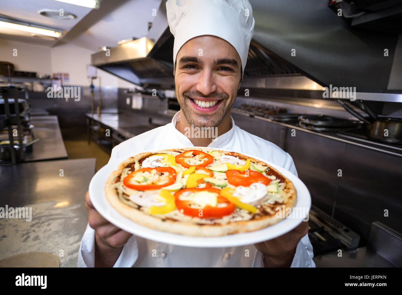 Handsome chef presenting pizza Stock Photo - Alamy