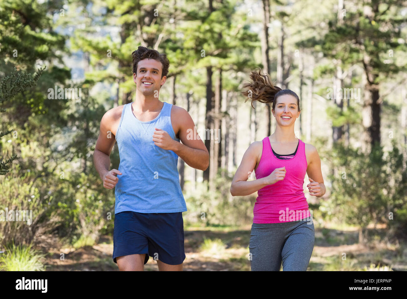 Young smiling couple jogging Stock Photo - Alamy