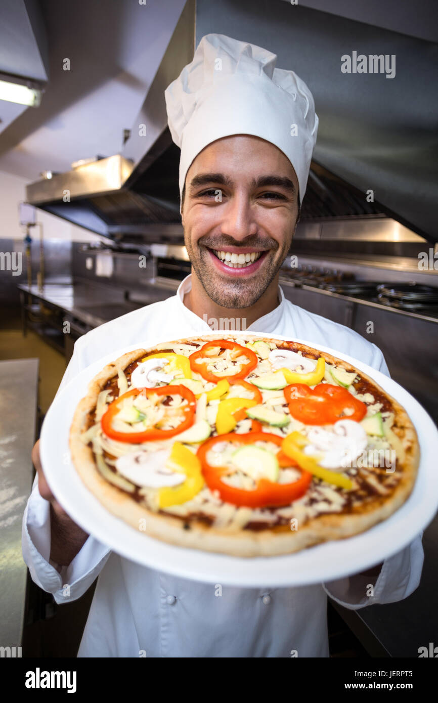 Handsome chef presenting pizza Stock Photo - Alamy