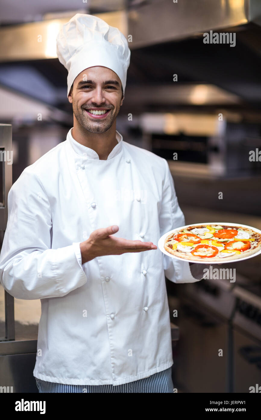 Handsome chef presenting pizza Stock Photo - Alamy