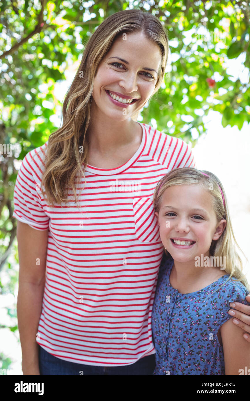 Smiling mother and daughter with arm around Stock Photo - Alamy