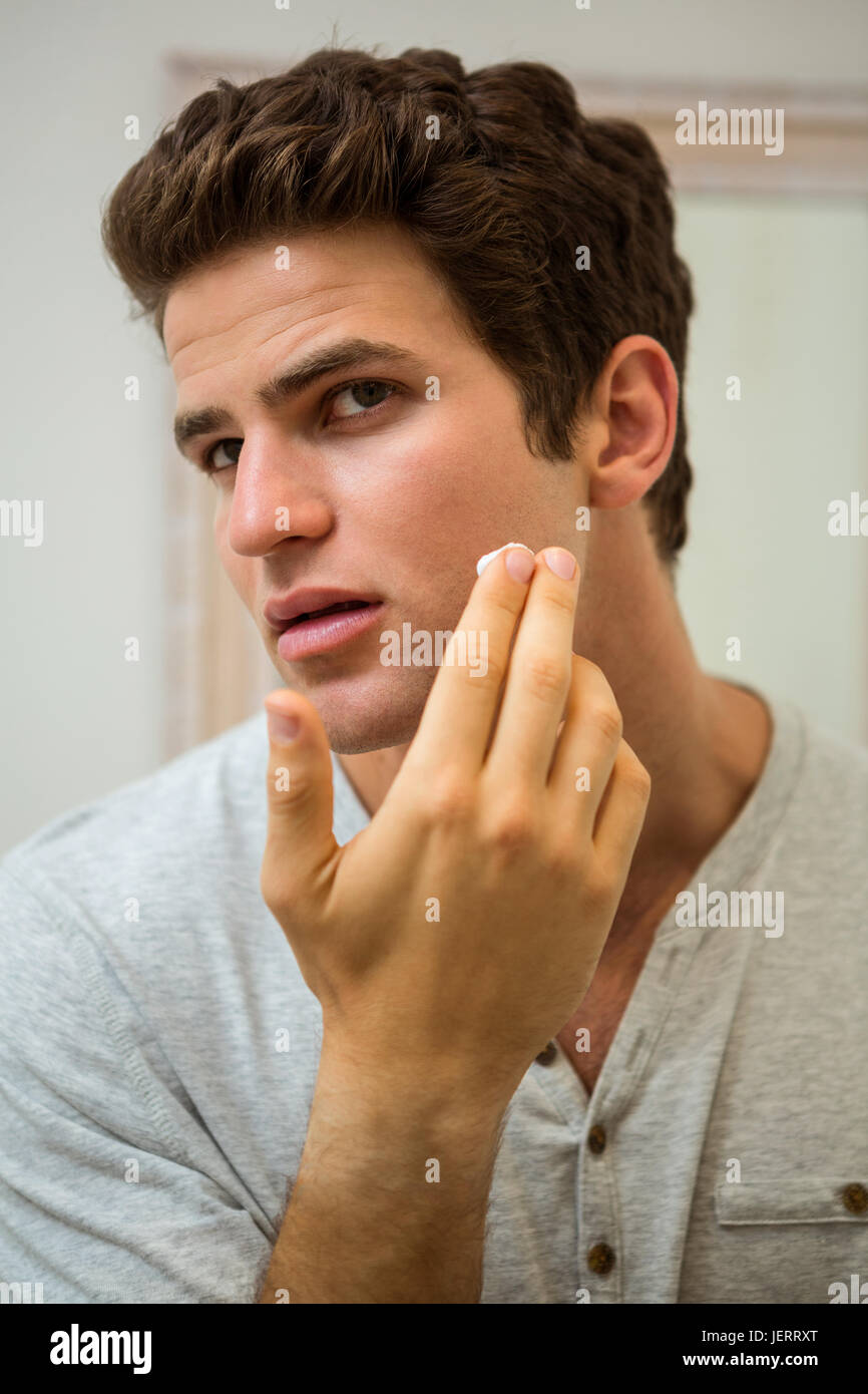 Man applying moisturizer on his face Stock Photo - Alamy