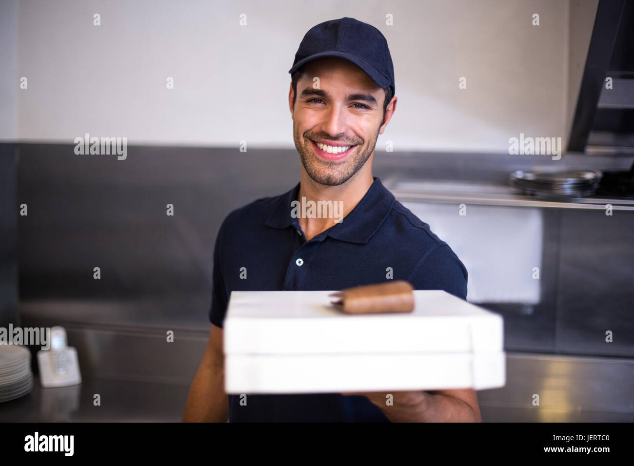 Pizza delivery man showing box Stock Photo - Alamy