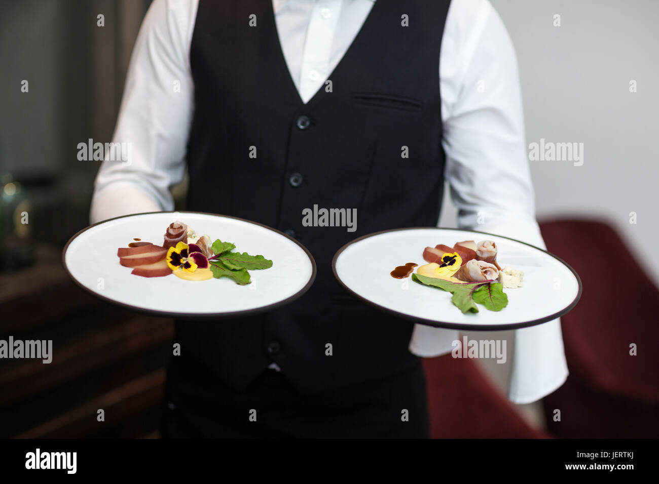 Portrait of waiter presenting meals Stock Photo - Alamy