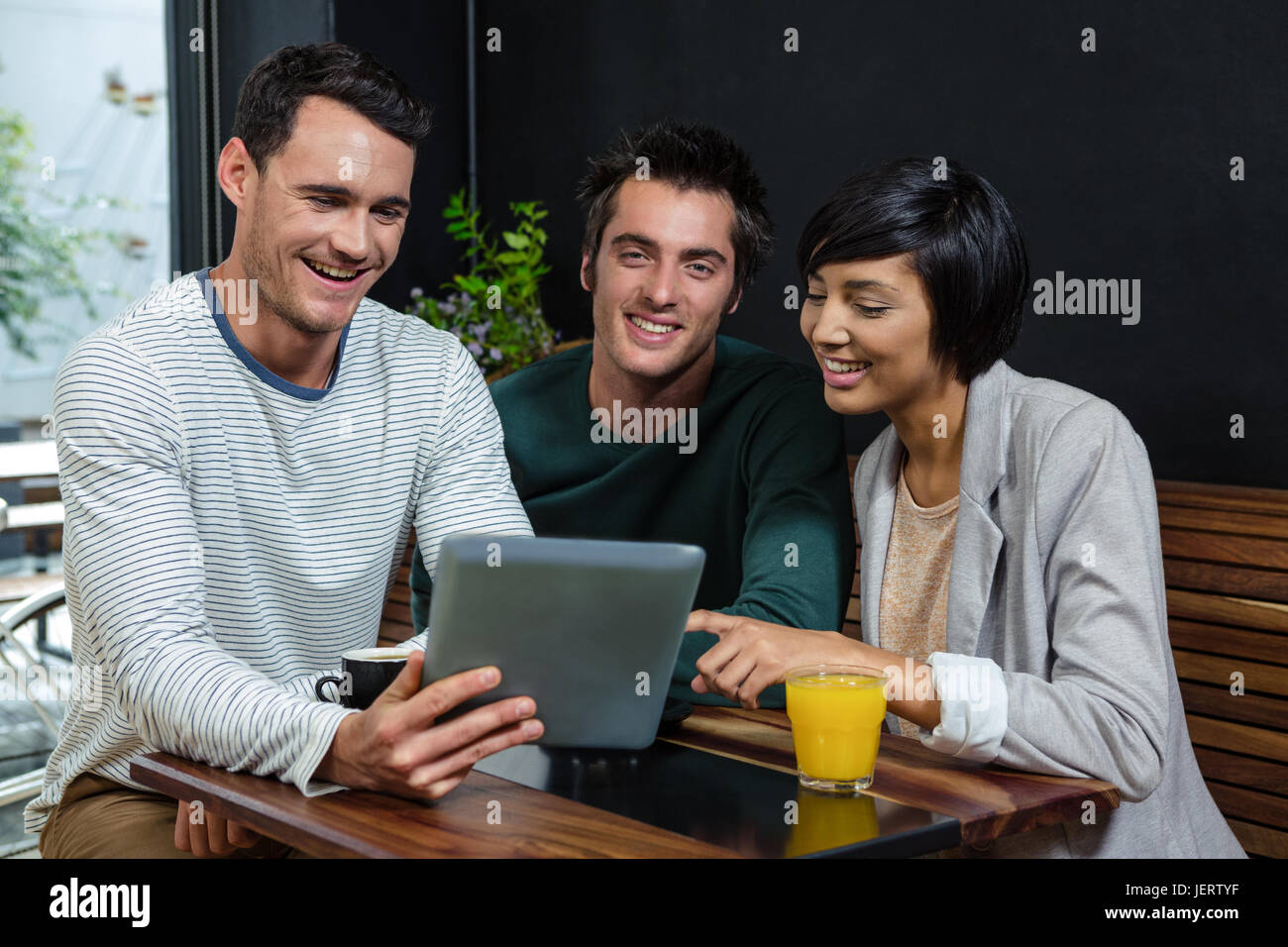 Relaxed happy friends using tablet hi-res stock photography and images ...