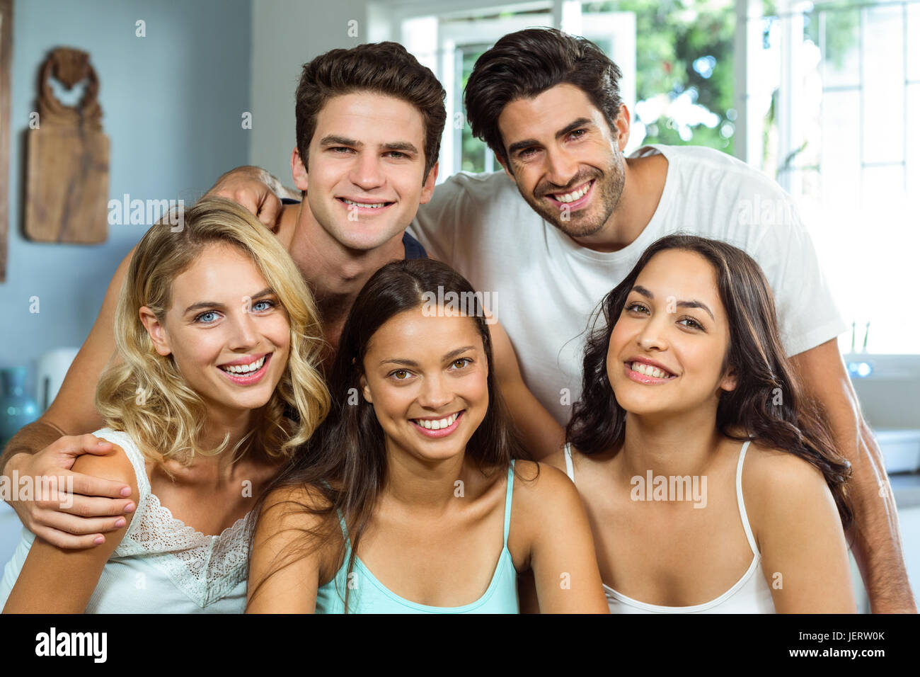 Happy young male and female friends at home Stock Photo - Alamy