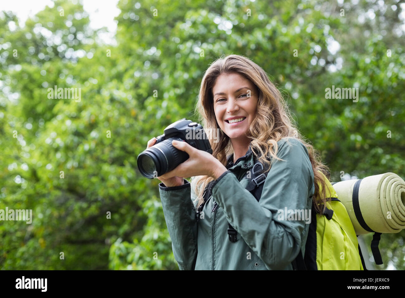 Portrait of happy woman with camera Stock Photo - Alamy