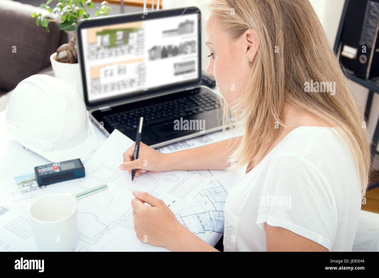 Young female architect is working at her new project at home office ...