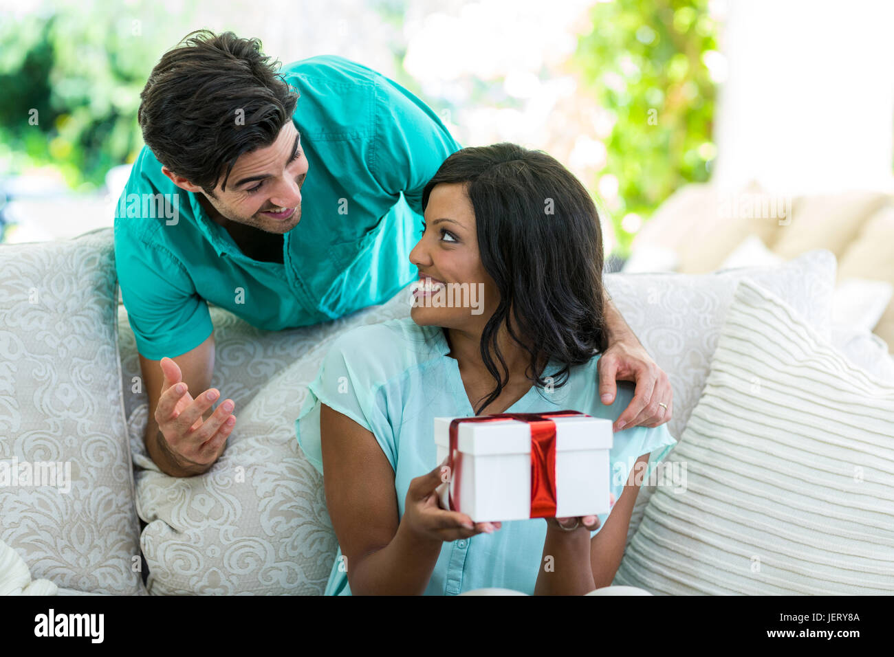 Man giving a surprise gift to woman Stock Photo - Alamy