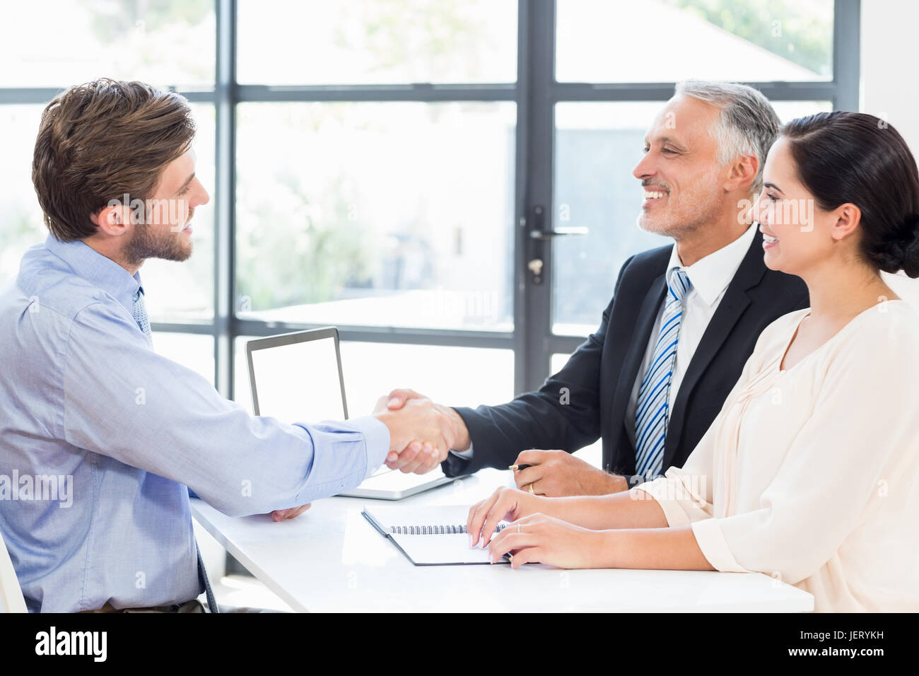 Businessmen shaking hands in office Stock Photo - Alamy