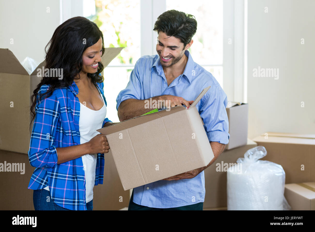 Young couple unpacking carton boxes Stock Photo - Alamy