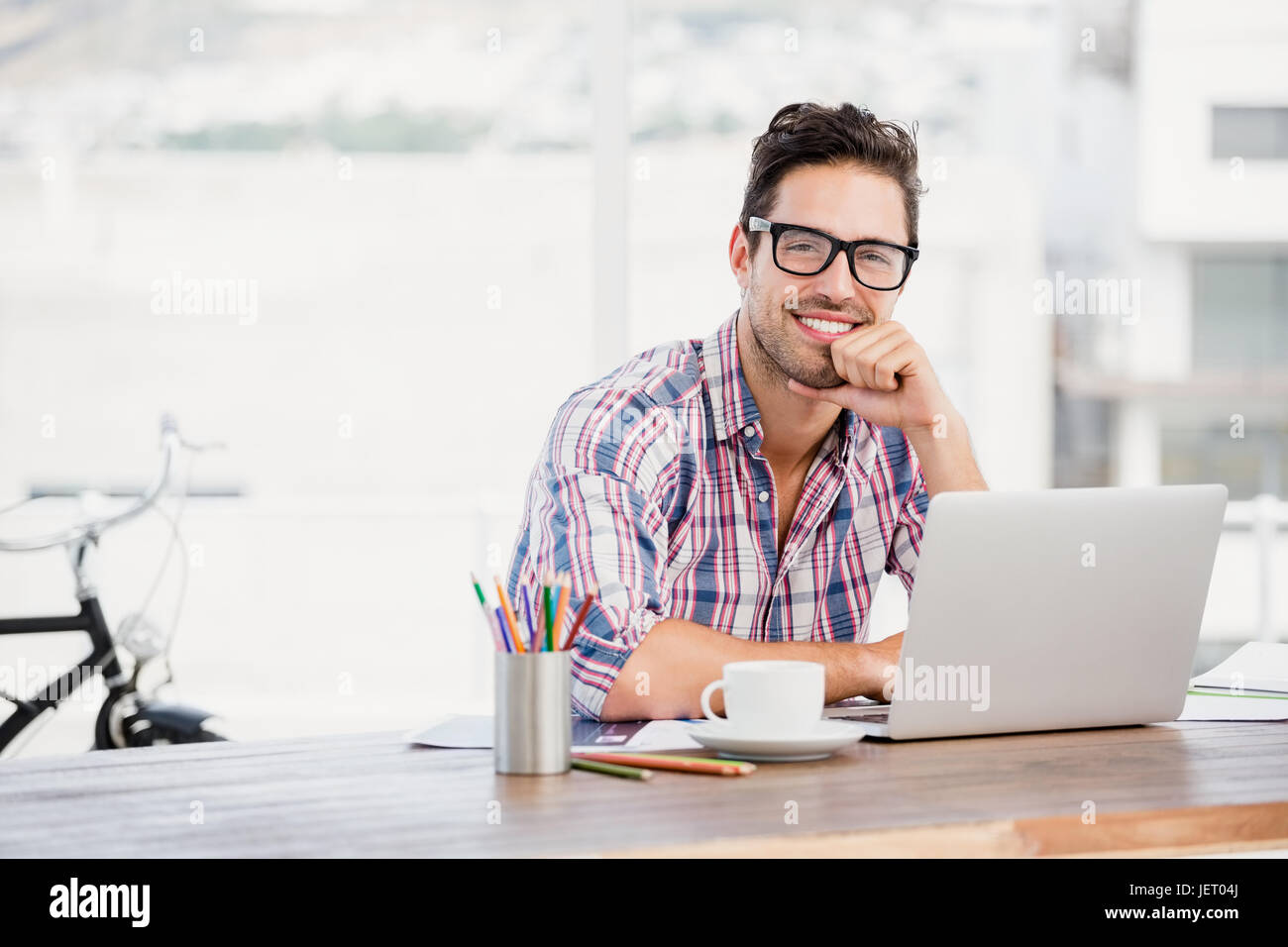Young man sitting at his desk Stock Photo - Alamy