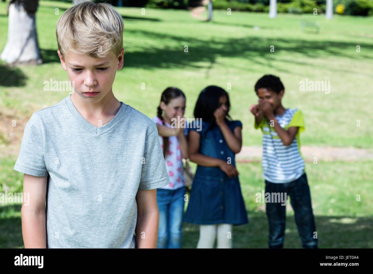 Friends teasing a boy Stock Photo - Alamy