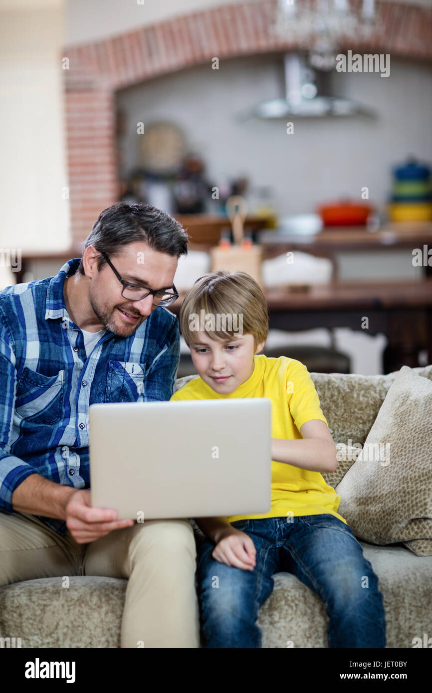Father and son using laptop in living room Stock Photo - Alamy