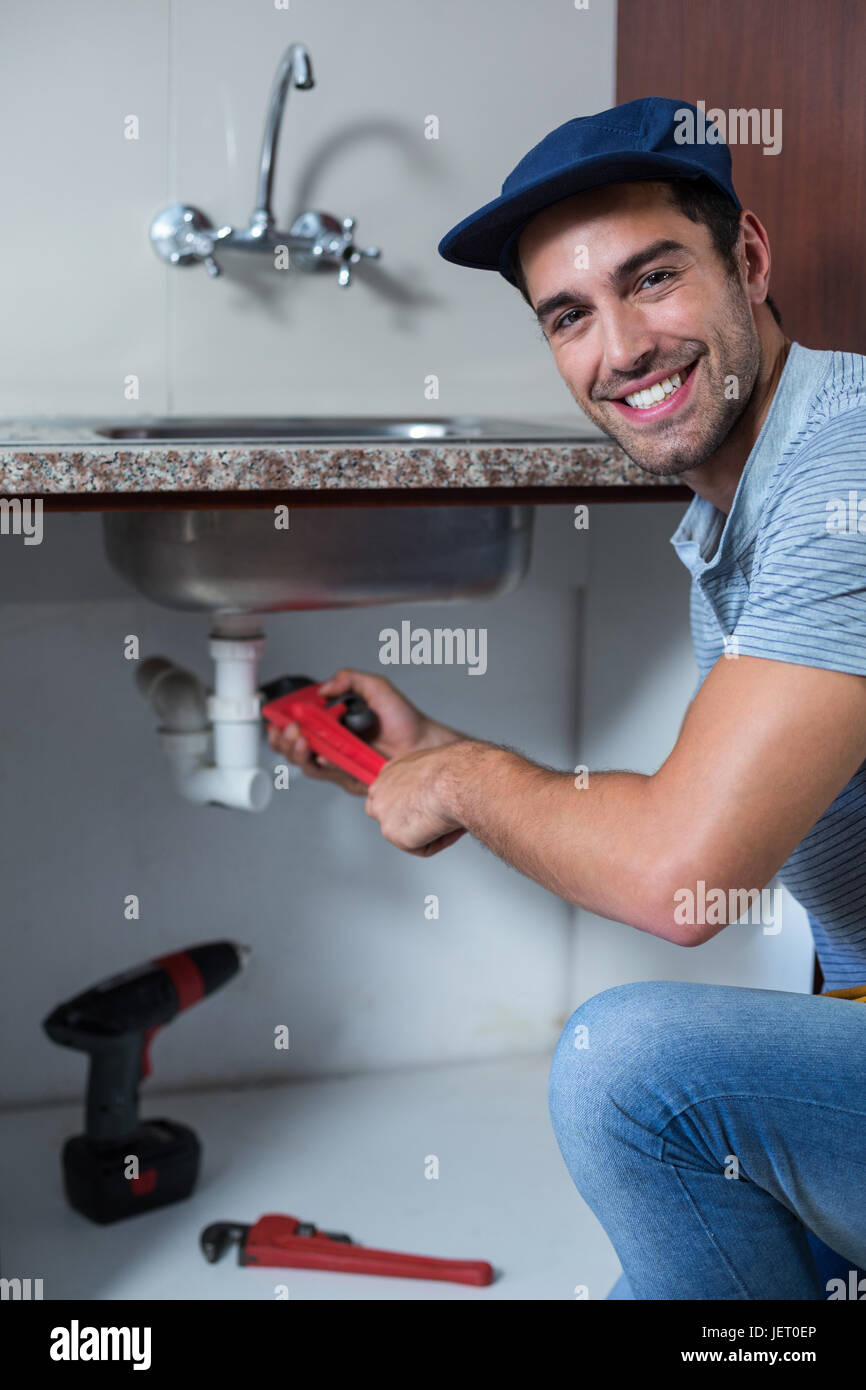 Portrait of man using pipe wrench Stock Photo - Alamy