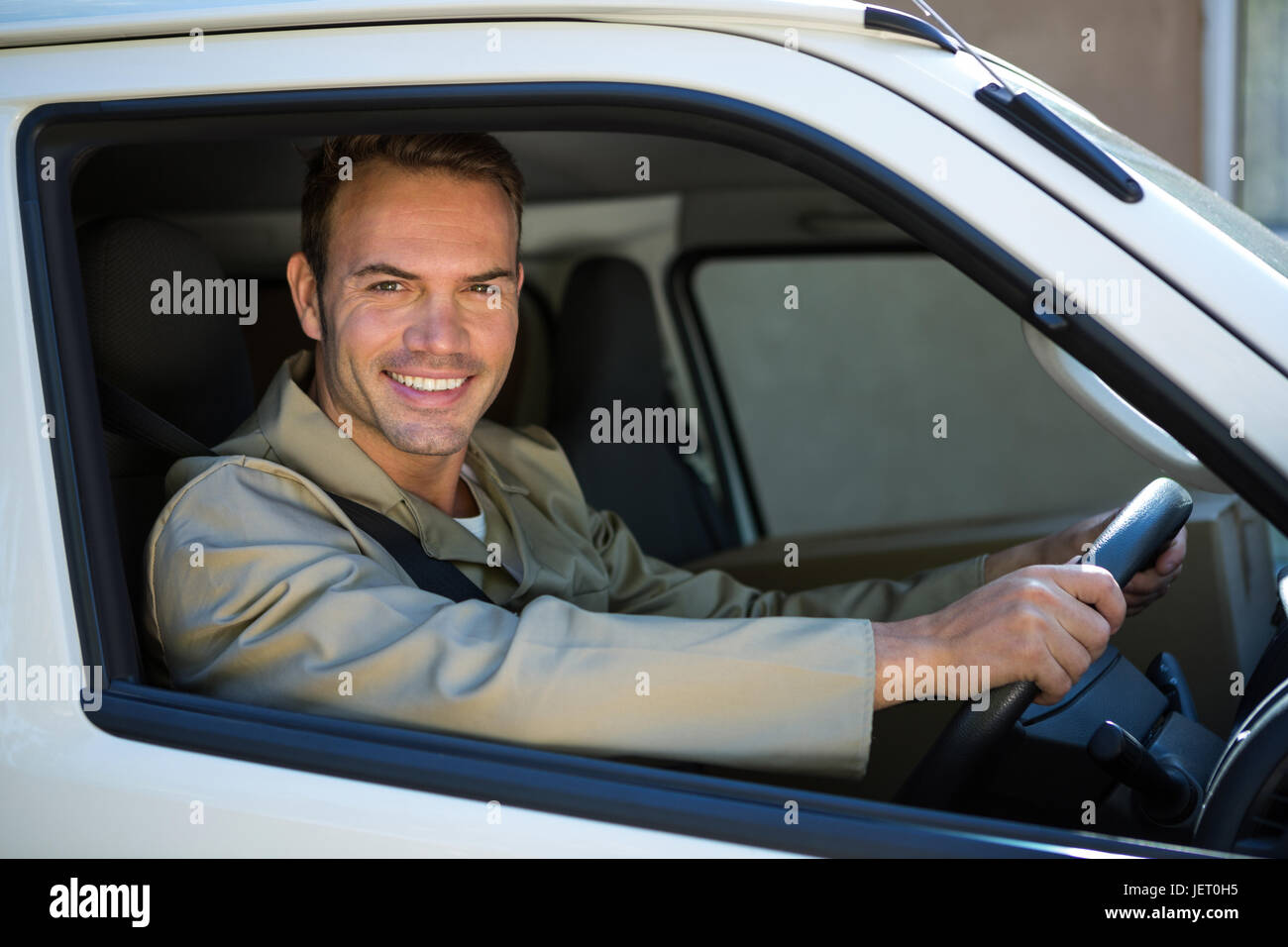 Delivery man driving in his van Stock Photo - Alamy