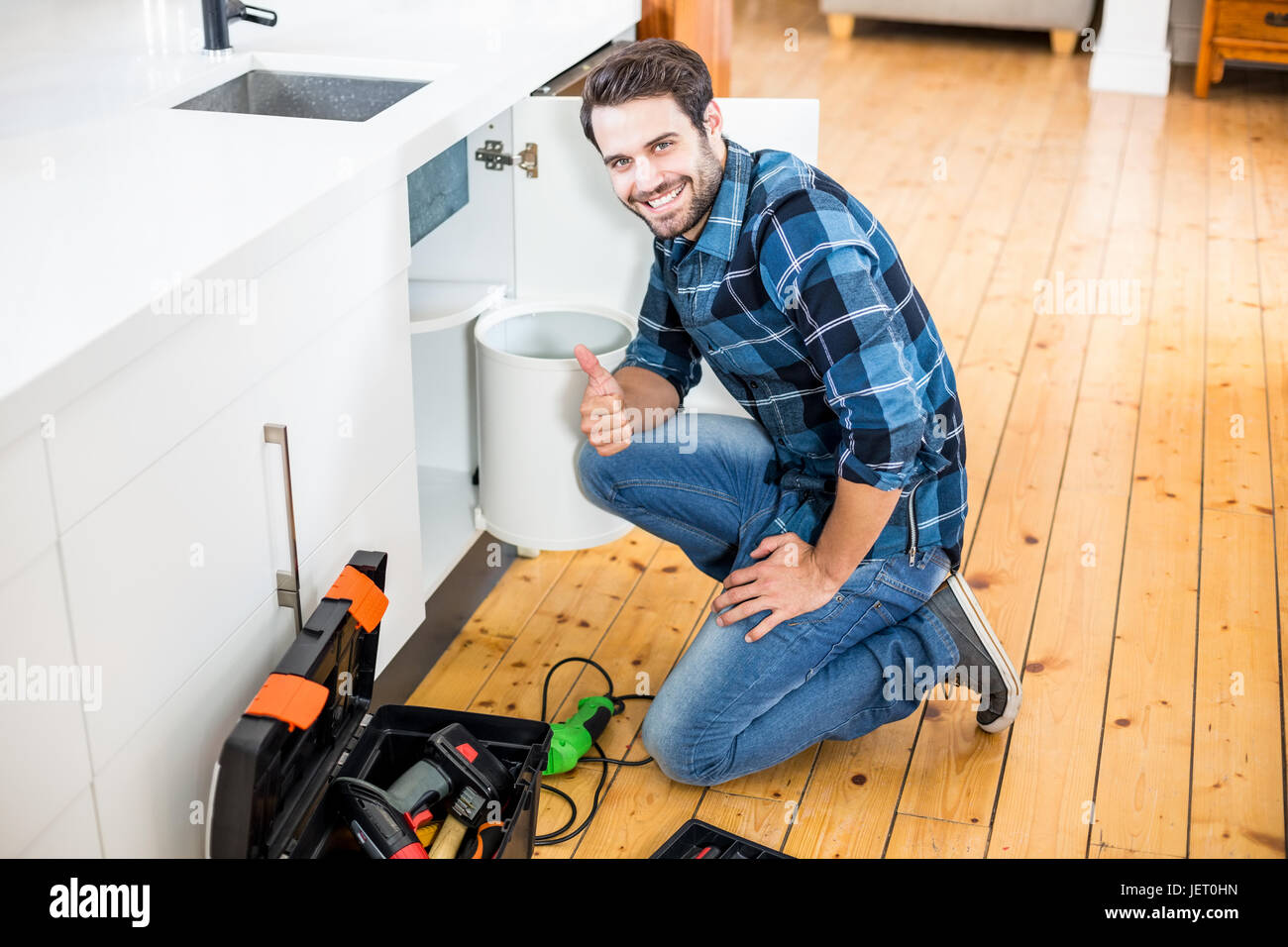 Man fixing kitchen sink giving thumbs up Stock Photo - Alamy