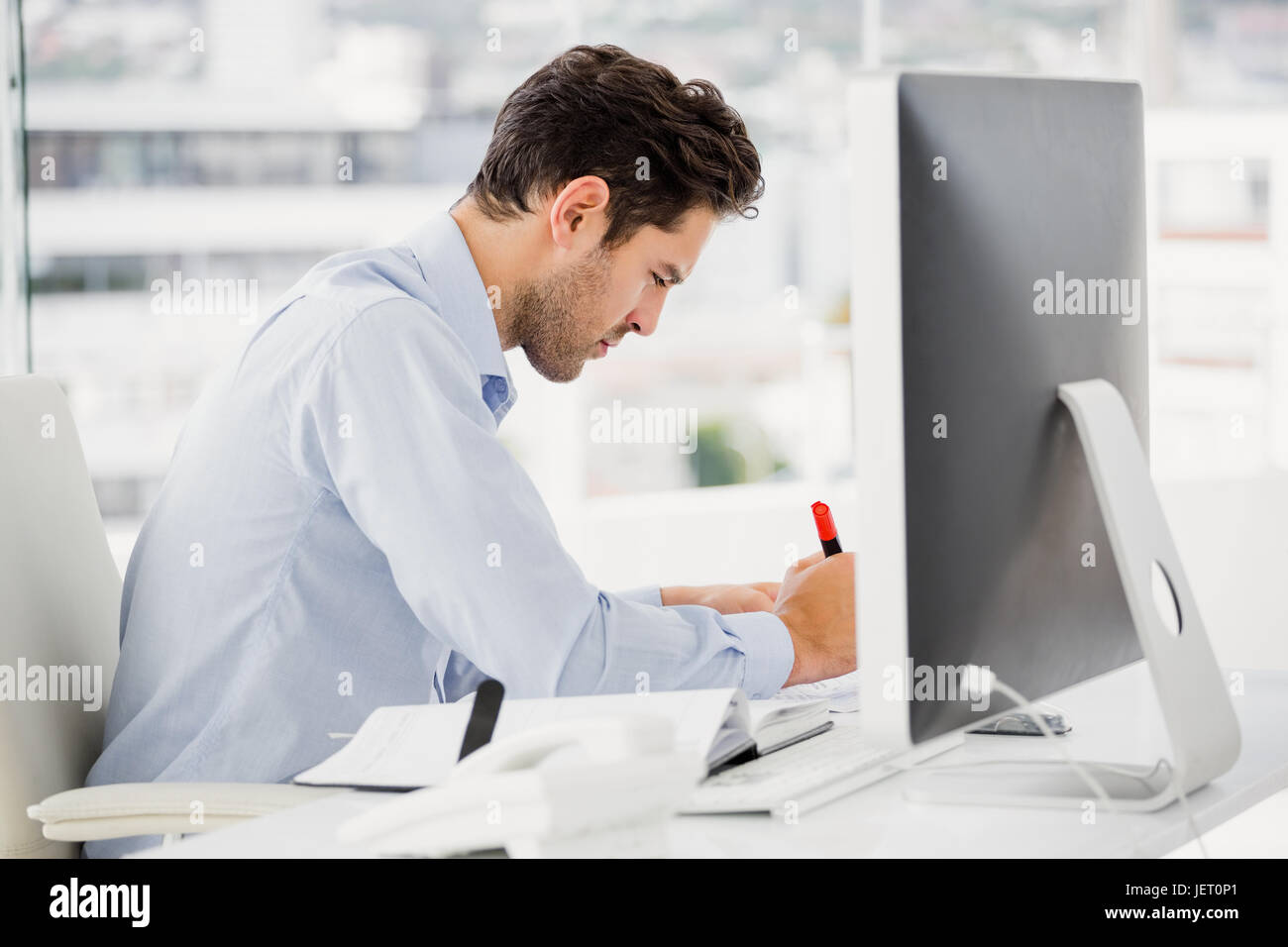 Businessman taking notes at his desk Stock Photo - Alamy
