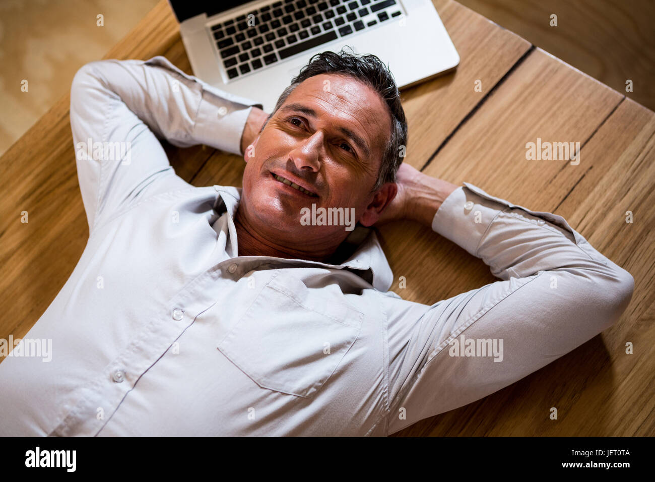 Thoughtful man lying on desk Stock Photo - Alamy