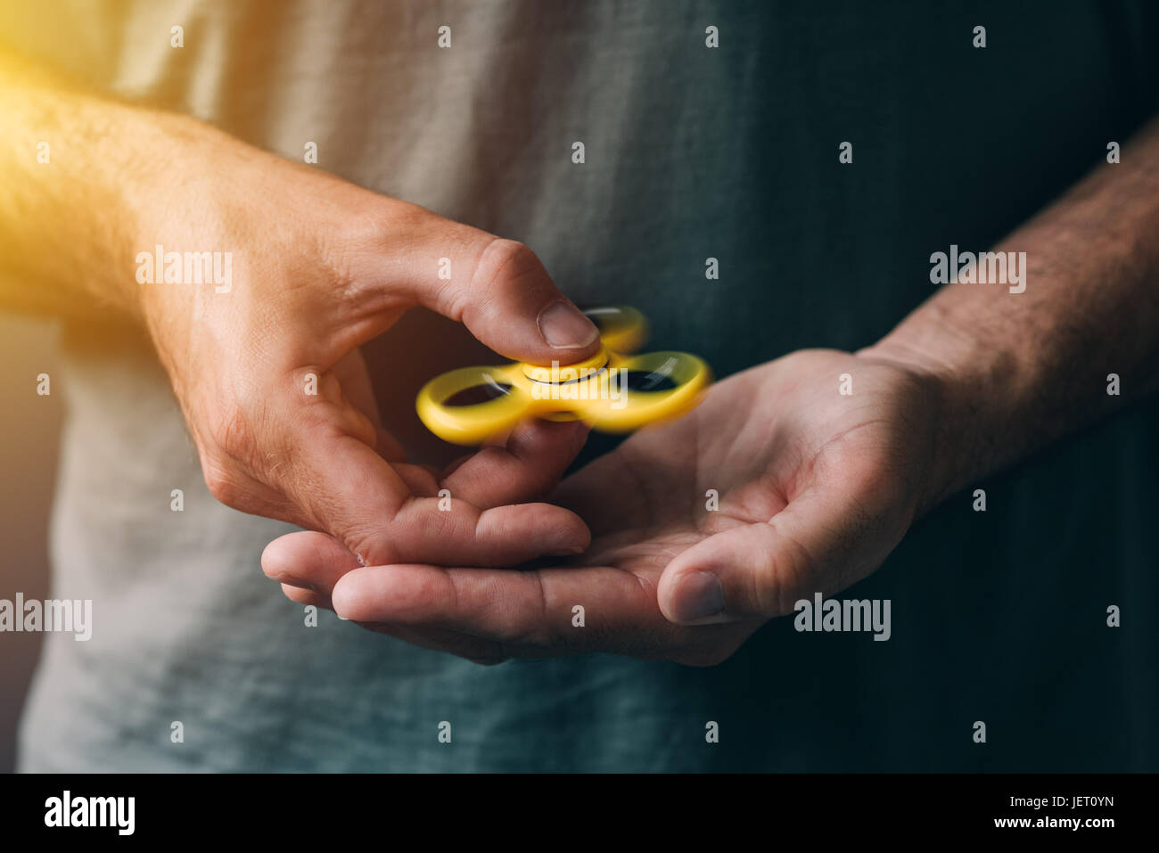Man playing with fidget spinner, very popular modern toy for relaxation ...