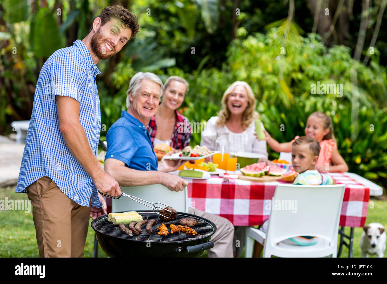 Father grilling food on barbeque at yard Stock Photo - Alamy