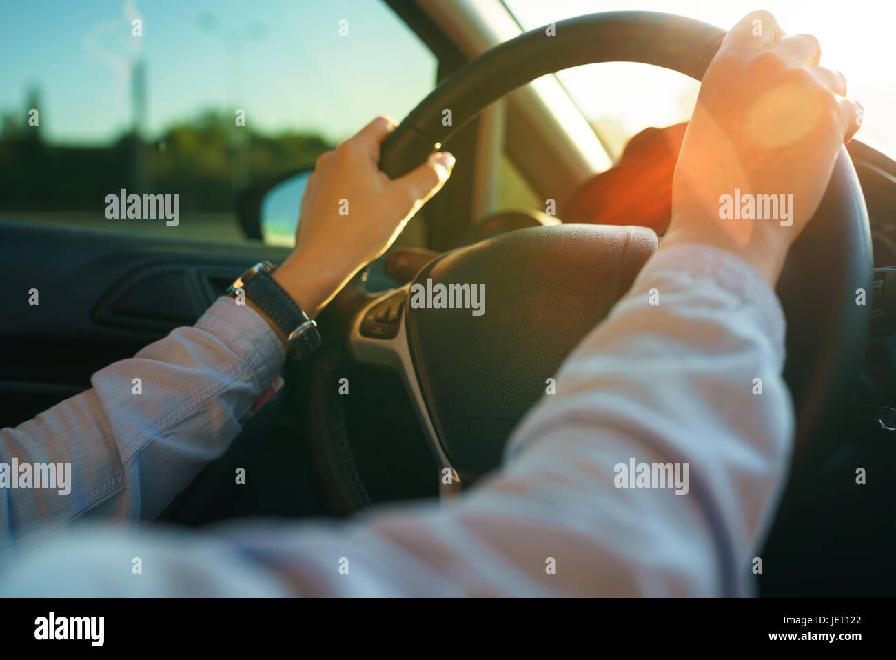 Close-up of female hands on the steering wheel at sunset Stock Photo ...