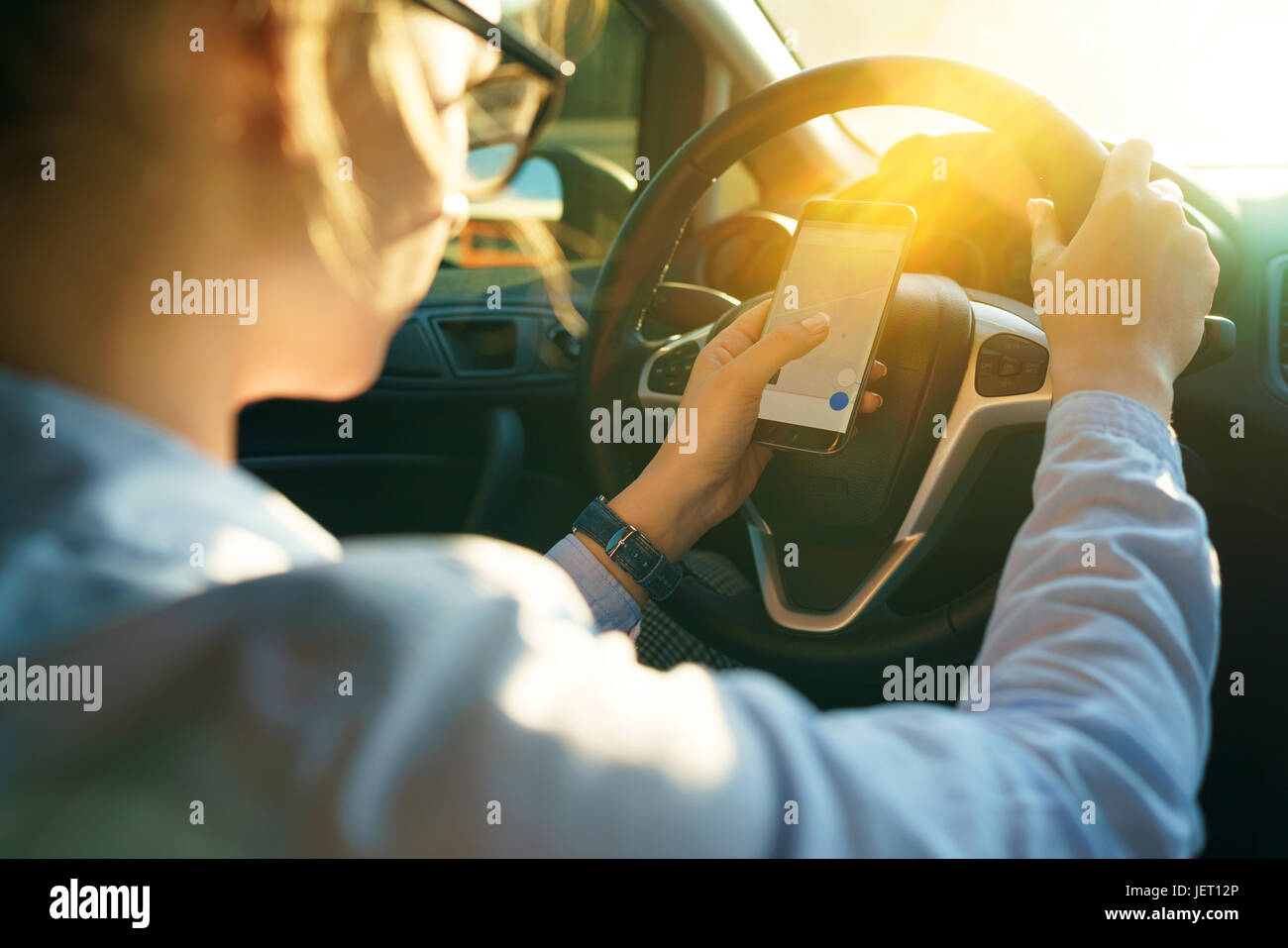 Woman uses a navigator in a smartphone while driving a car Stock Photo ...