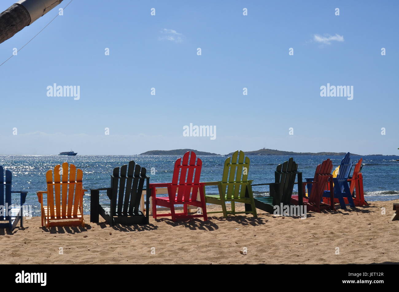 Colorful Beach Chairs in the sand facing the water Stock Photo - Alamy