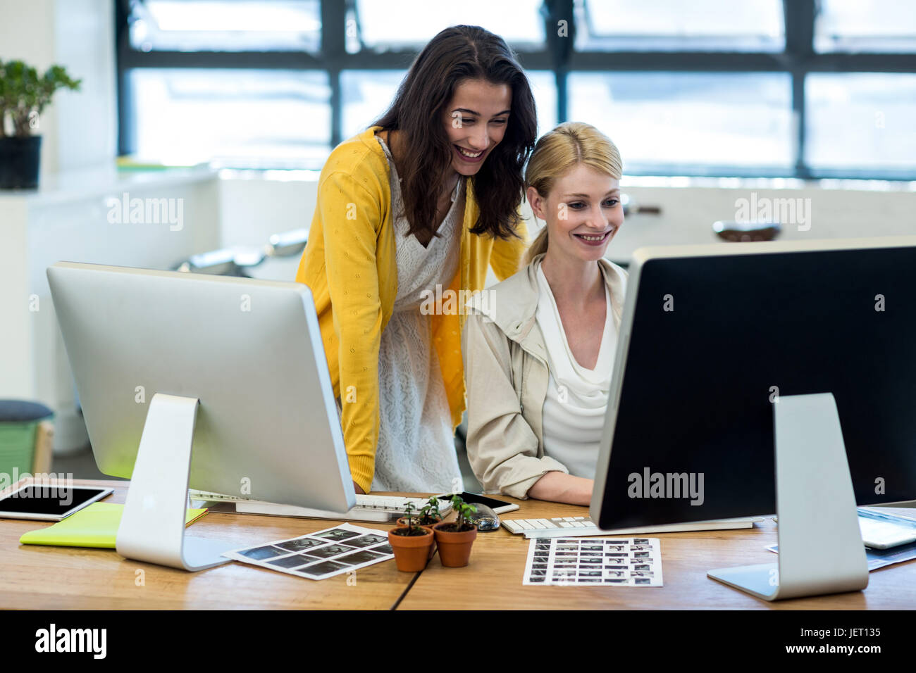 Colleagues working on computer together Stock Photo - Alamy