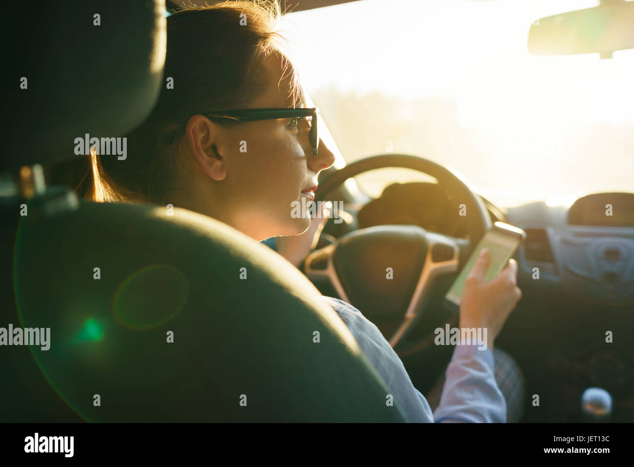 Woman uses a navigator in a smartphone while driving a car Stock Photo ...