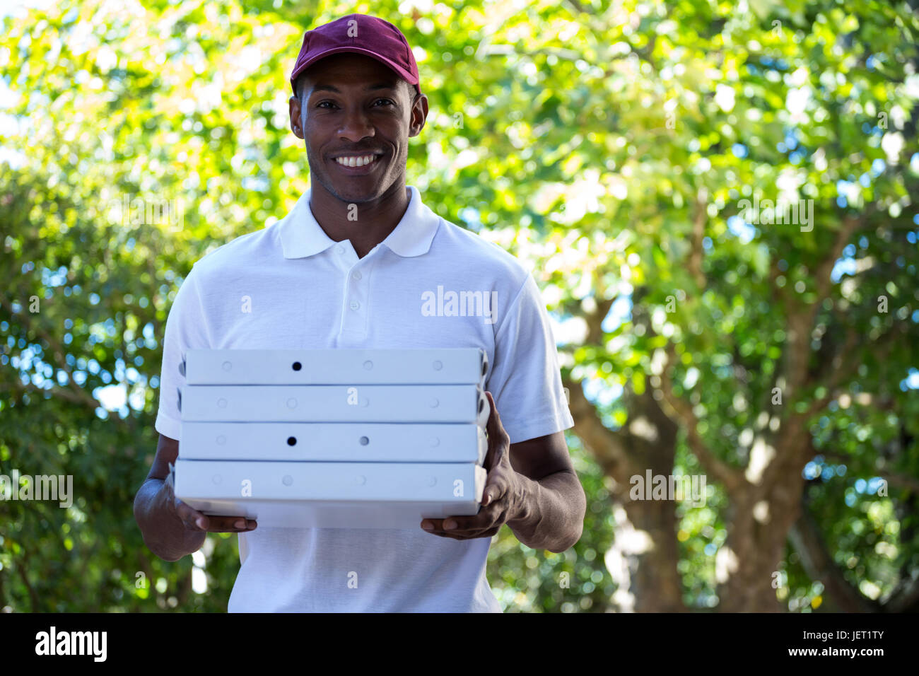 Happy delivery man holding pizza boxes Stock Photo - Alamy