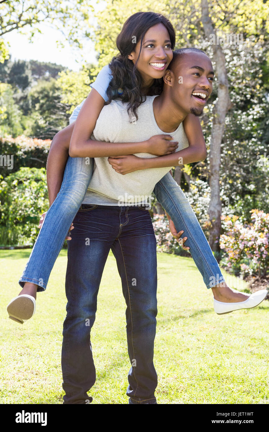 Young man giving piggyback ride to woman Stock Photo - Alamy