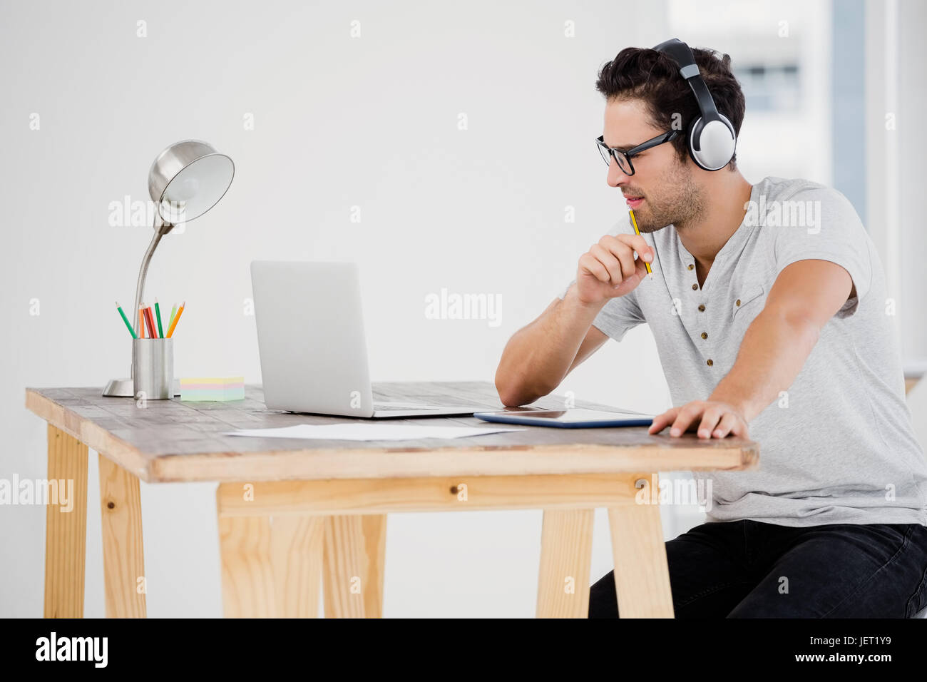 Young man working at his desk Stock Photo - Alamy