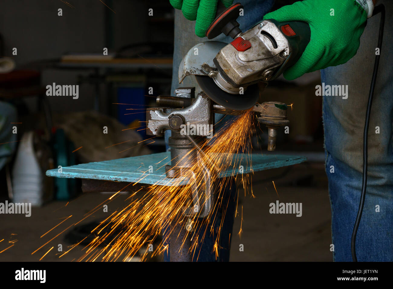 Worker with angular grinding machine is cutting the metal and a lot of ...