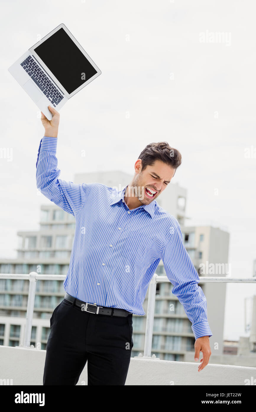Frustrated businessman throwing laptop Stock Photo - Alamy