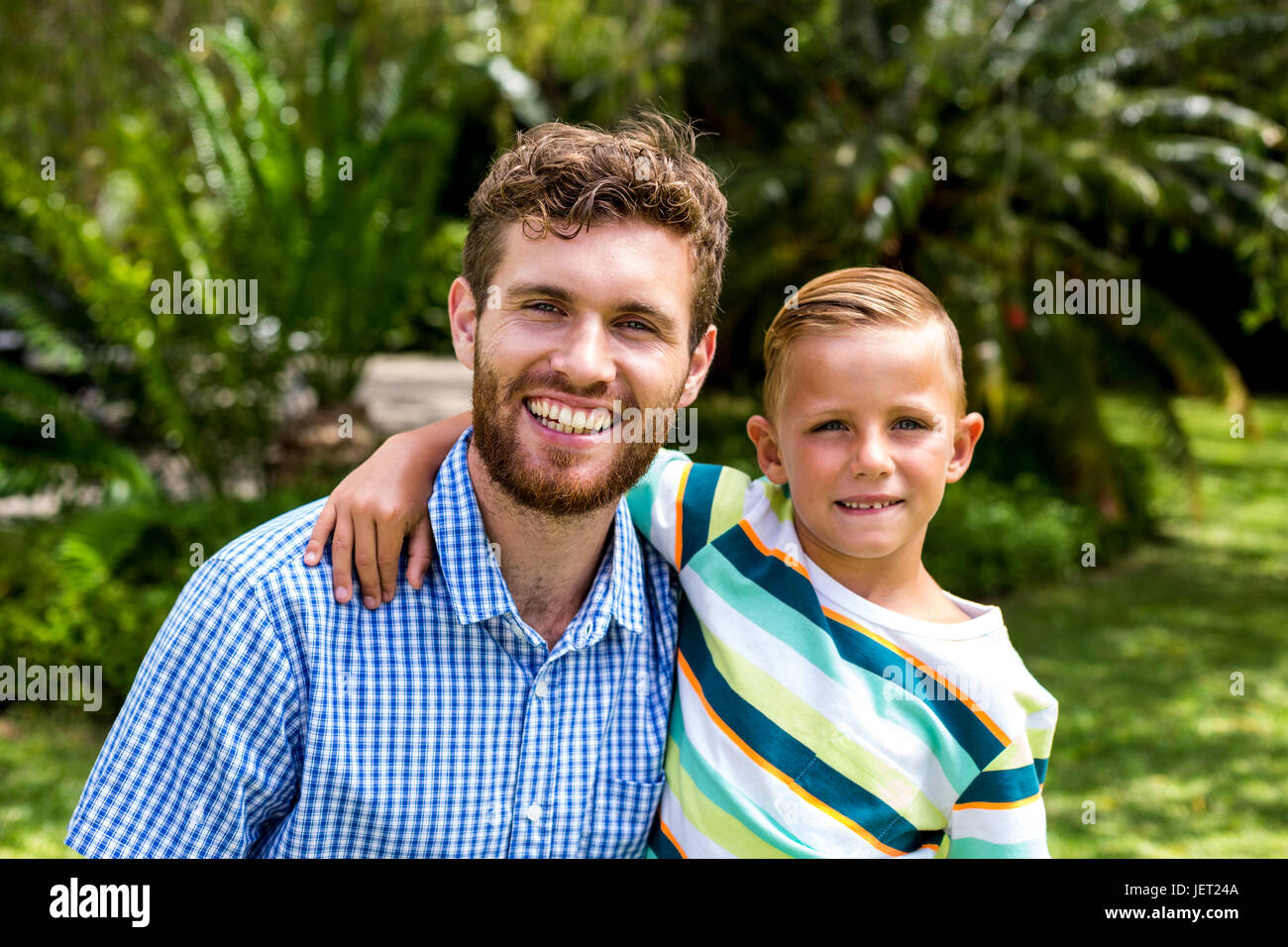 Portrait of smiling father and son in yard Stock Photo - Alamy