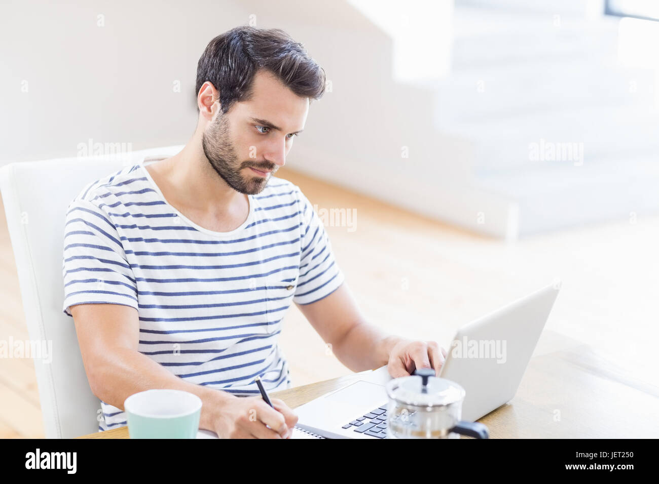 Man writing note using laptop Stock Photo - Alamy
