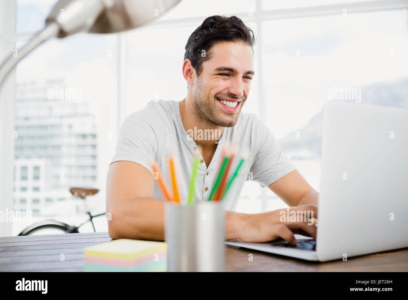 Young man working at his desk Stock Photo - Alamy