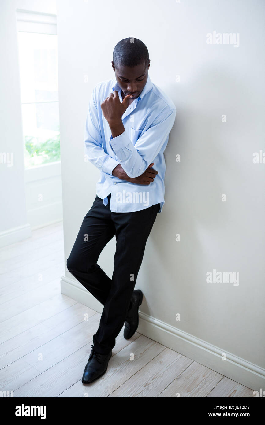 Tensed man leaning on wall Stock Photo - Alamy