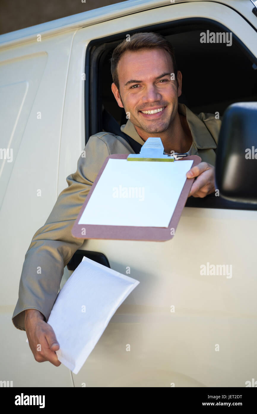 Smiling delivery man sitting in his van Stock Photo - Alamy