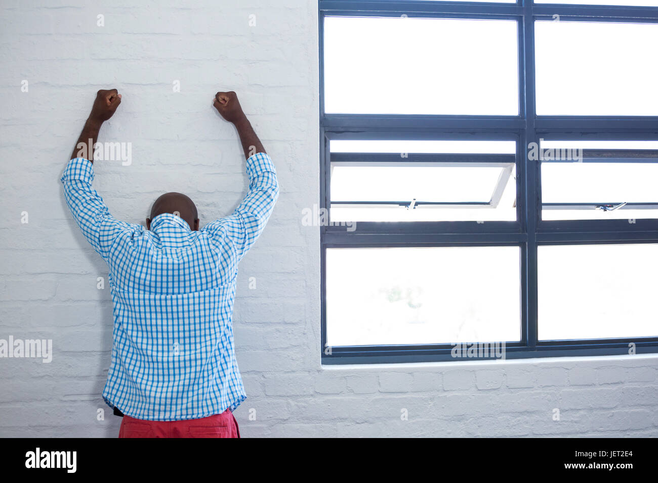 Upset man leaning against wall Stock Photo - Alamy