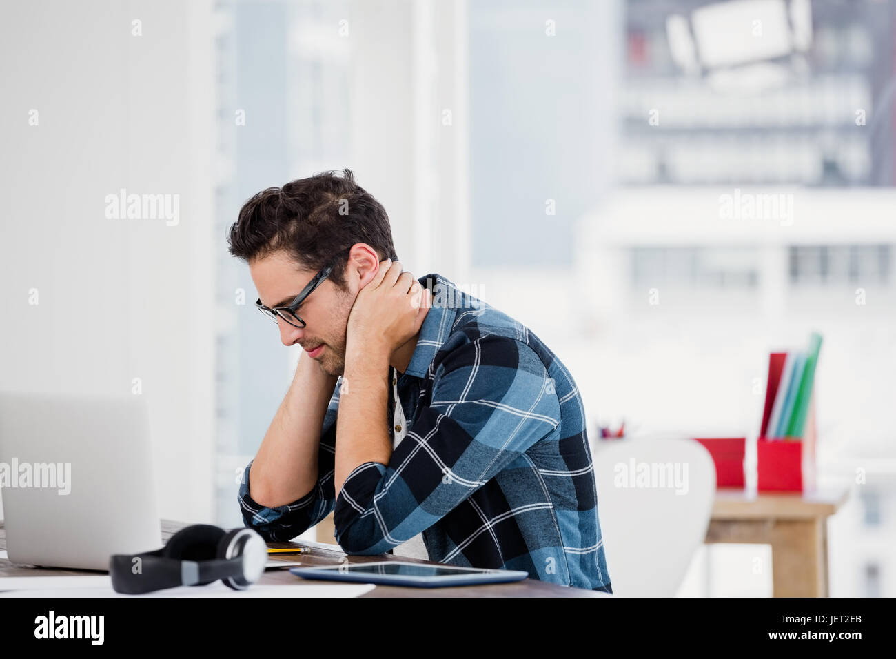 Stressed young man sitting at his desk Stock Photo - Alamy