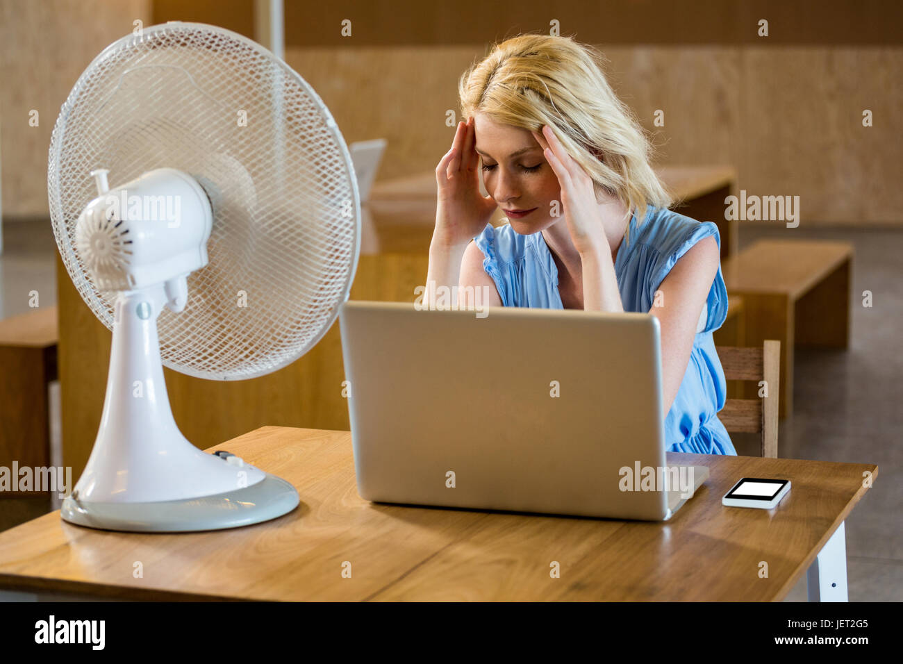 Tense woman sitting in desk Stock Photo - Alamy