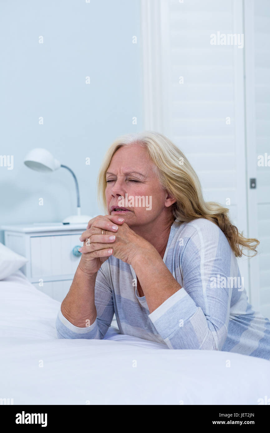 Woman praying in bedroom Stock Photo - Alamy