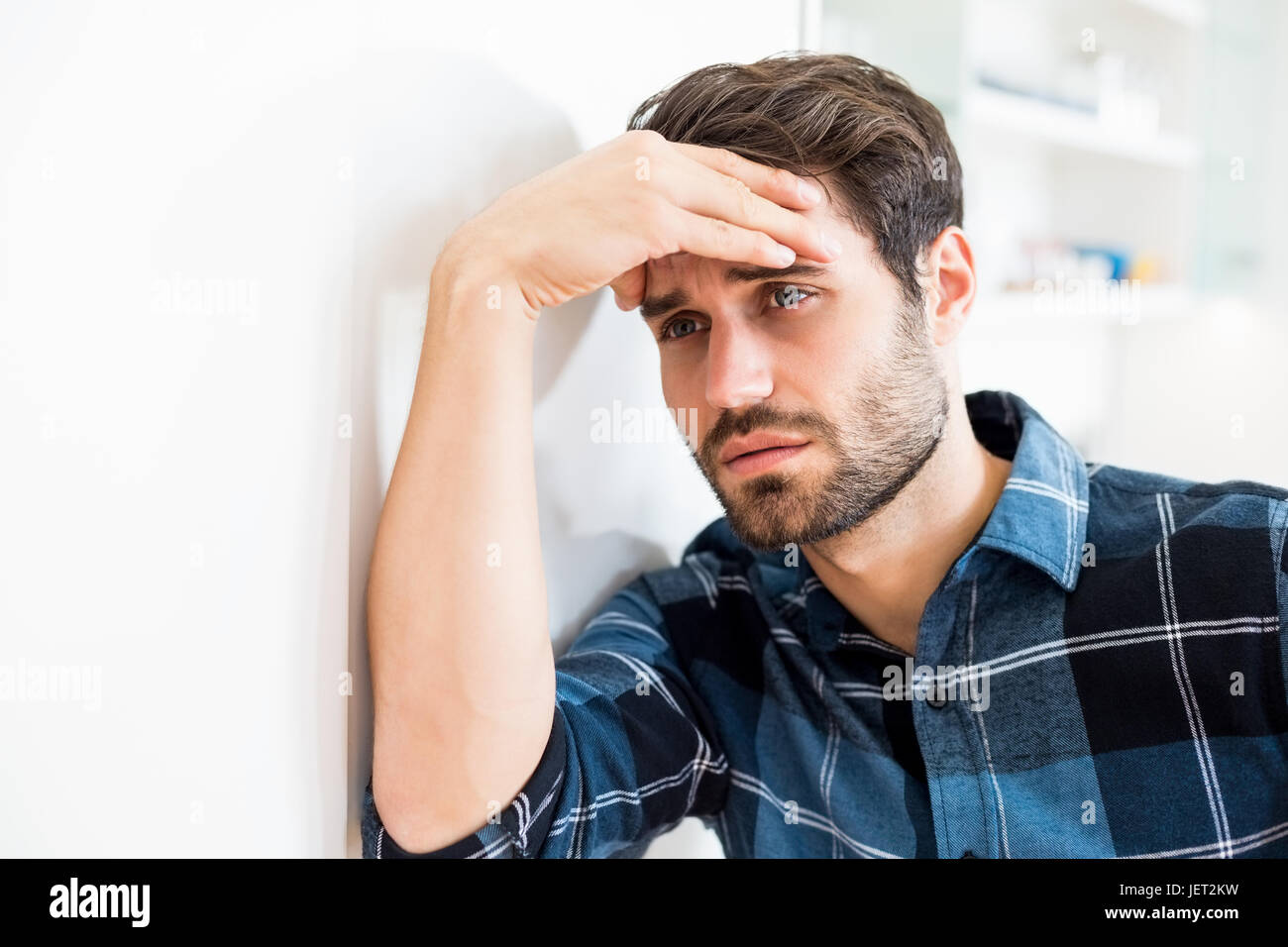 Depressed man leaning on wall Stock Photo - Alamy