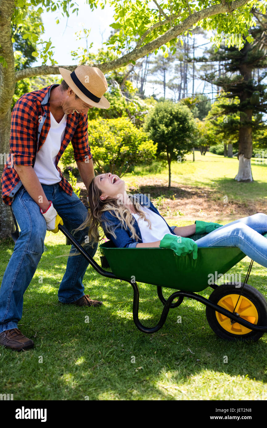 Happy couple playing with a wheelbarrow Stock Photo - Alamy