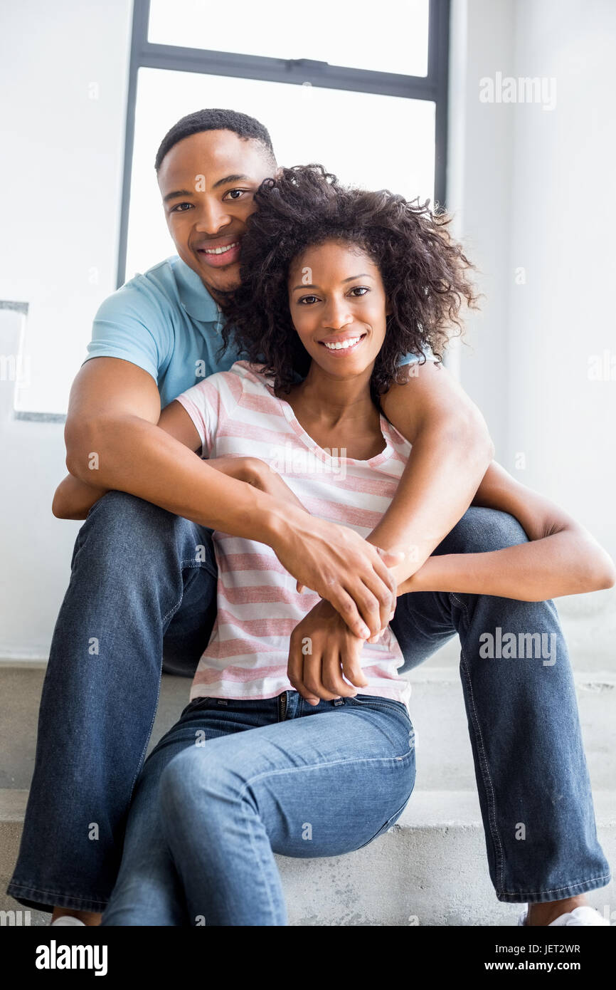 Young couple embracing on steps Stock Photo - Alamy