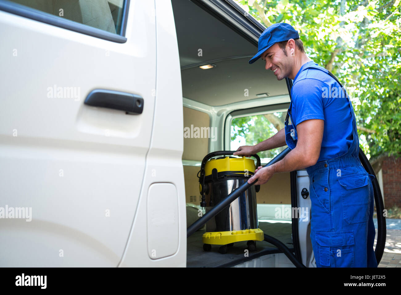 Happy janitor cleaning the car Stock Photo - Alamy
