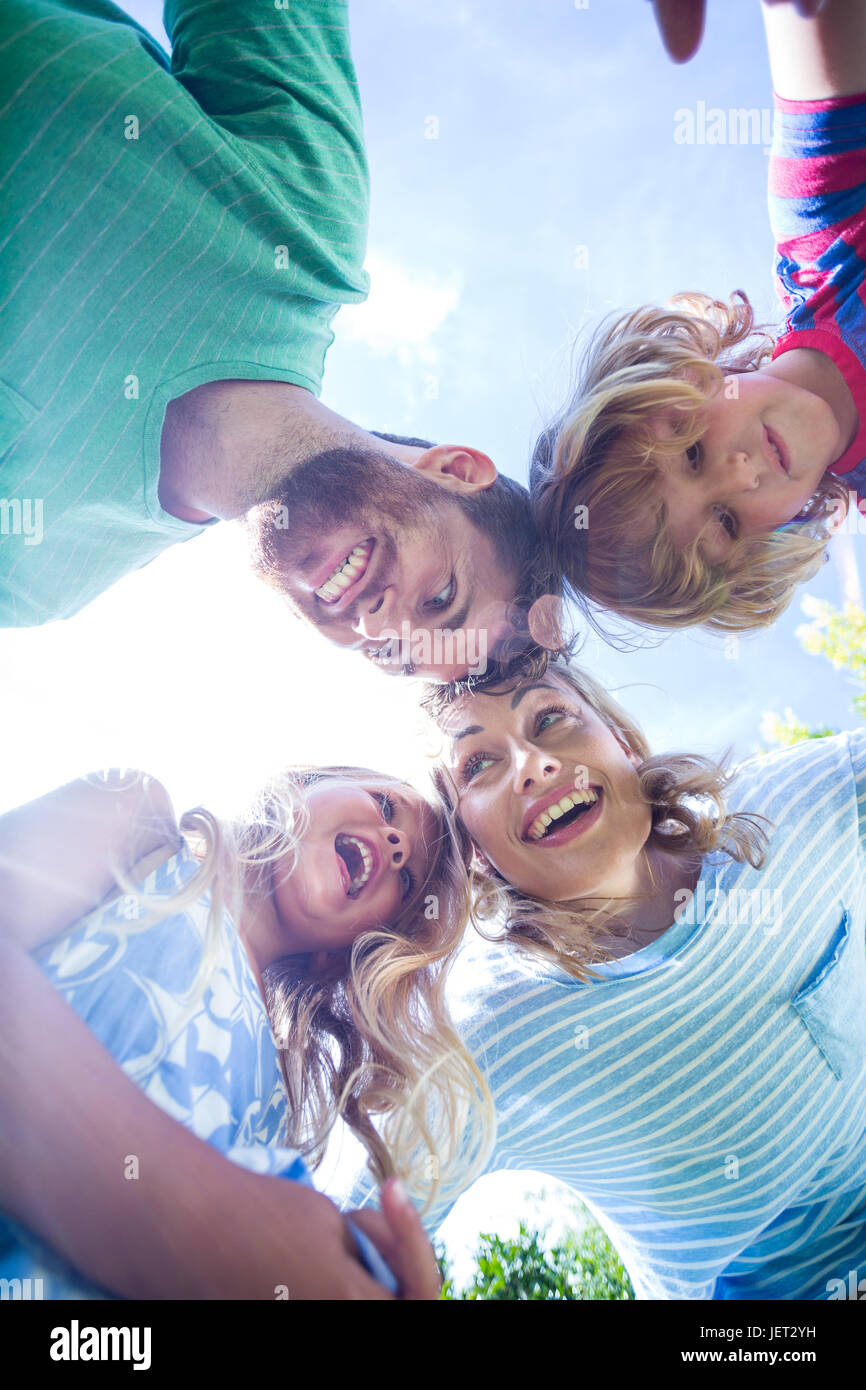 Happy family forming huddle in yard Stock Photo - Alamy